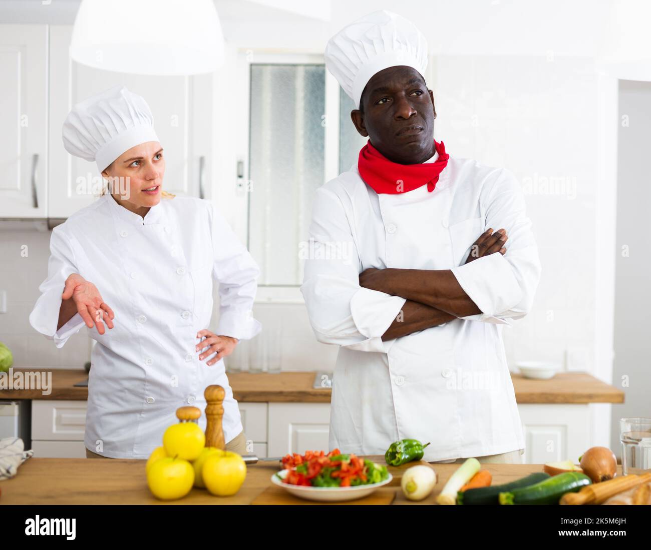 Chefs in white uniform having conflict on kitchen Stock Photo - Alamy