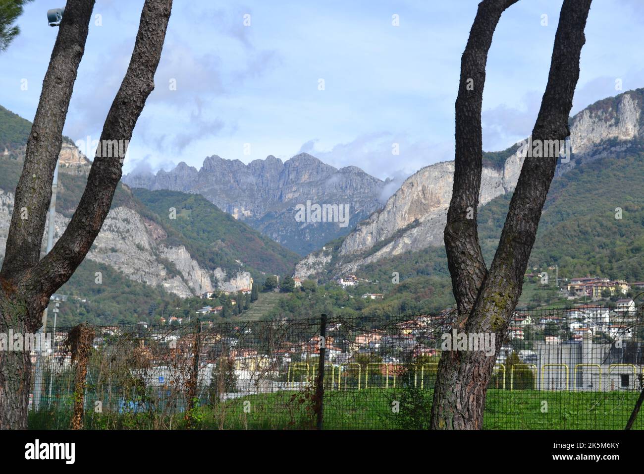 Panoramic view of Mount Resegone from the park through trunks of two ...