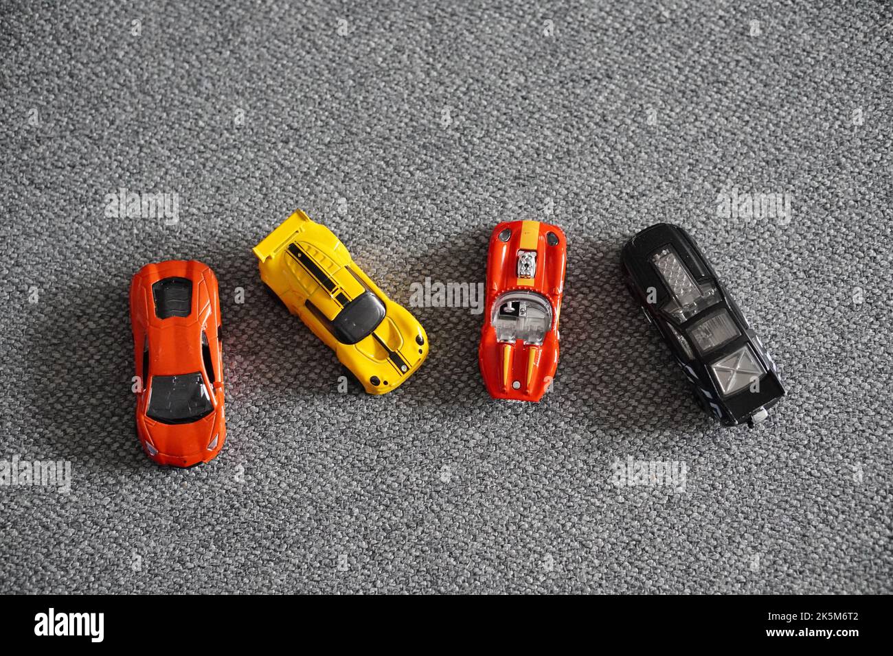 A group of multi-color toy cars on a gray rough surface Stock Photo - Alamy