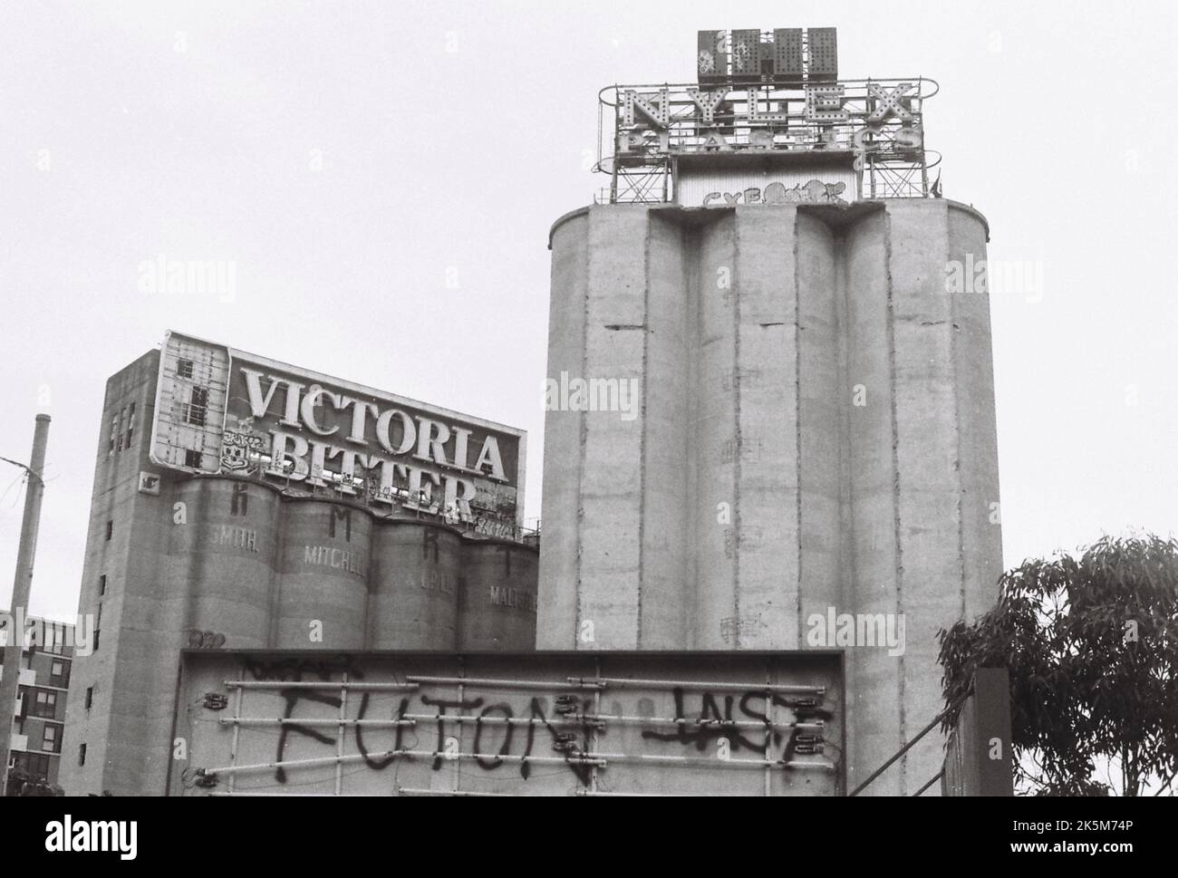 A grayscale of the Nylex Clock and abandoned Victoria Bitter silos in ...