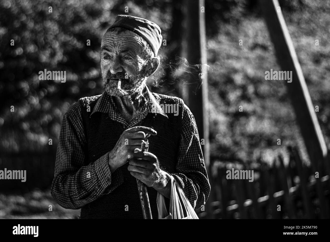 A grayscale portrait of an old man with a sajkaca hat looking aside ...