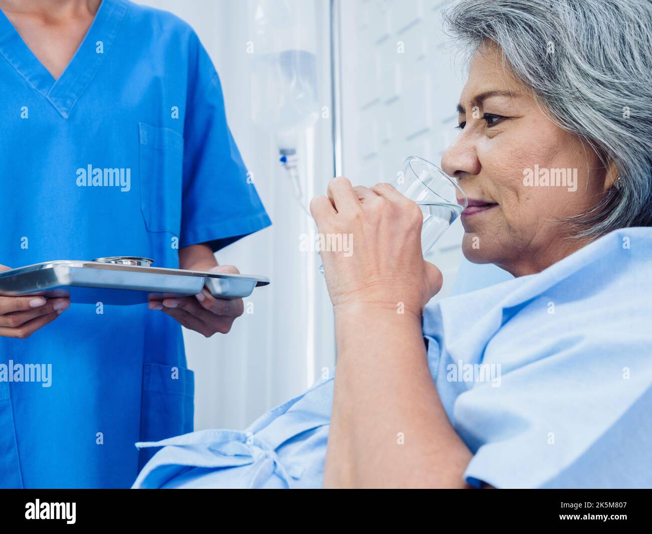 Asian elderly patient taking medicine, hold drinking water glass and ...
