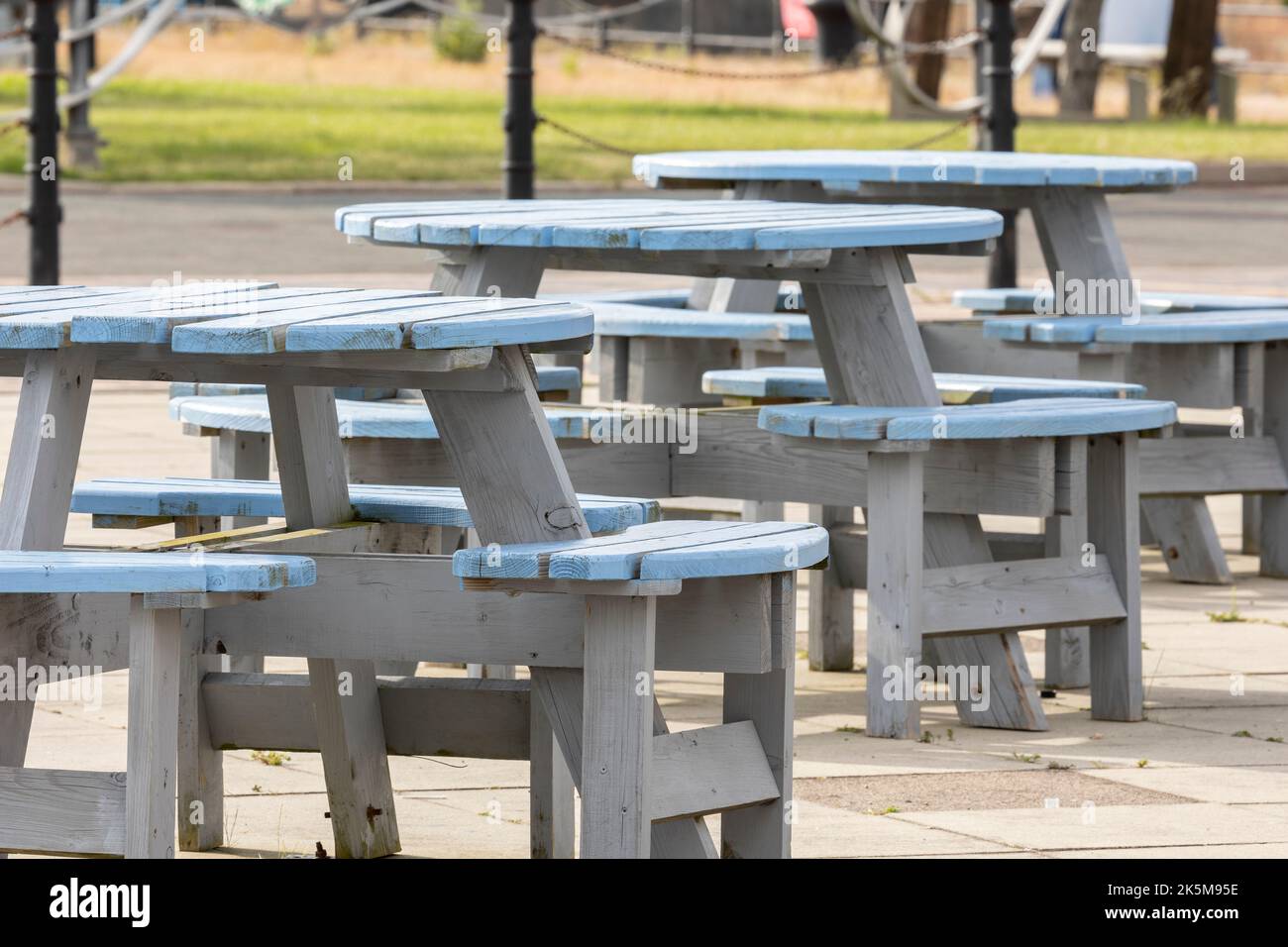 blue Round Wooden Outdoor Picnic Tables with Seats Stock Photo - Alamy