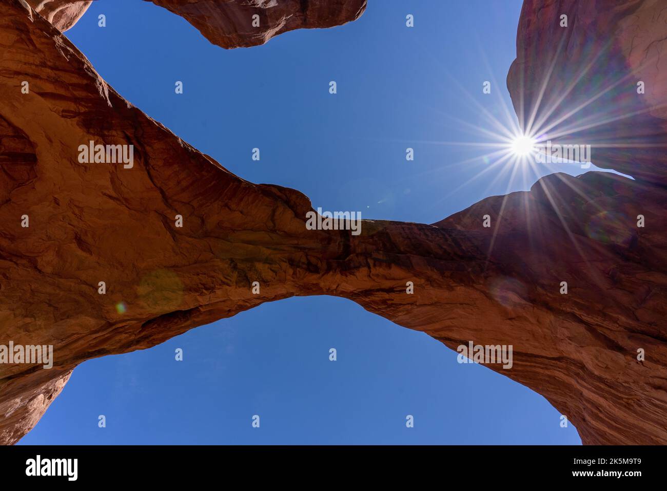 The natural arches against the sunny sky in the Arches National Park in ...