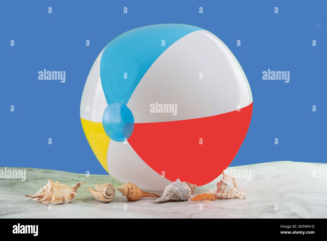 A beach ball with red, yellow, blue, and white stripes with various ...