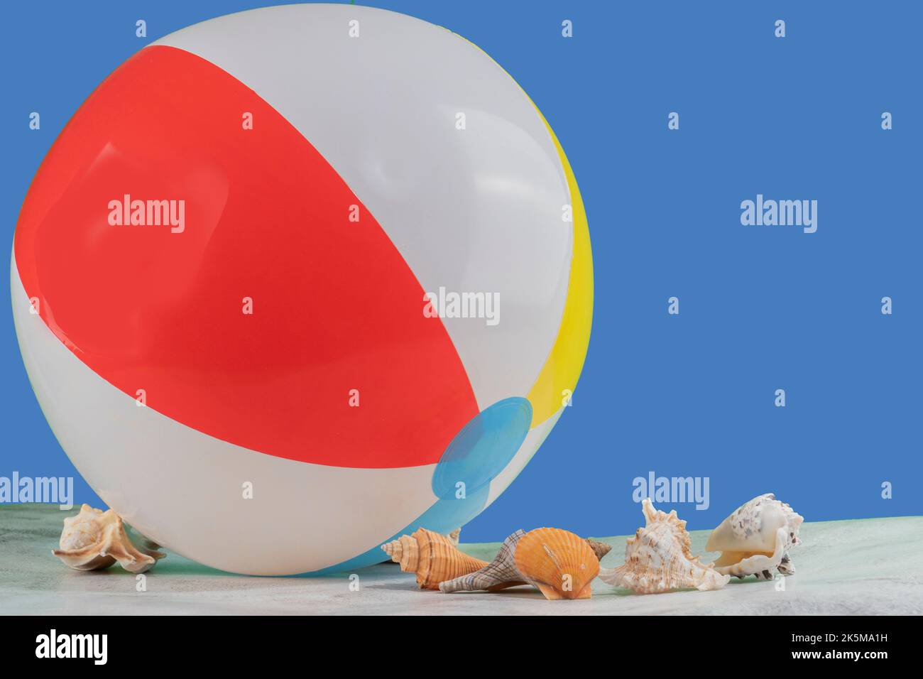 A beach ball with red, yellow, blue, and white stripes with various ...