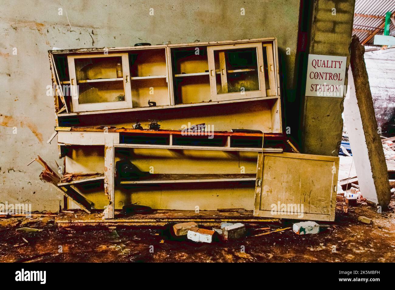 Severely broken work bench and shelves with a sign saying "Quality ...