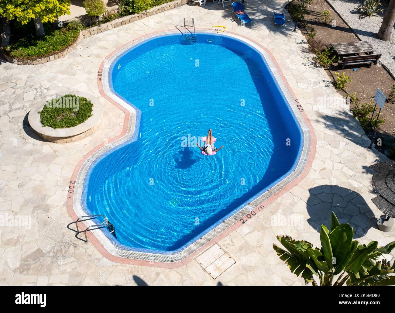 View from above of a lady relaxing on an air bed in a swimming pool ...