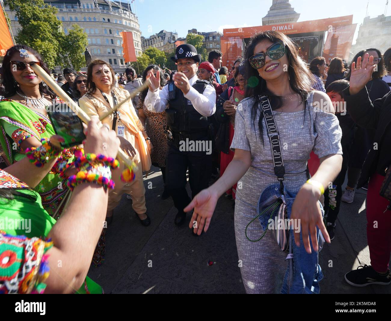 A police officer dances with members of the public during the Diwali on ...