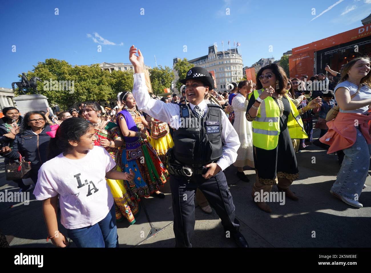 A police officer dances with members of the public during the Diwali on ...