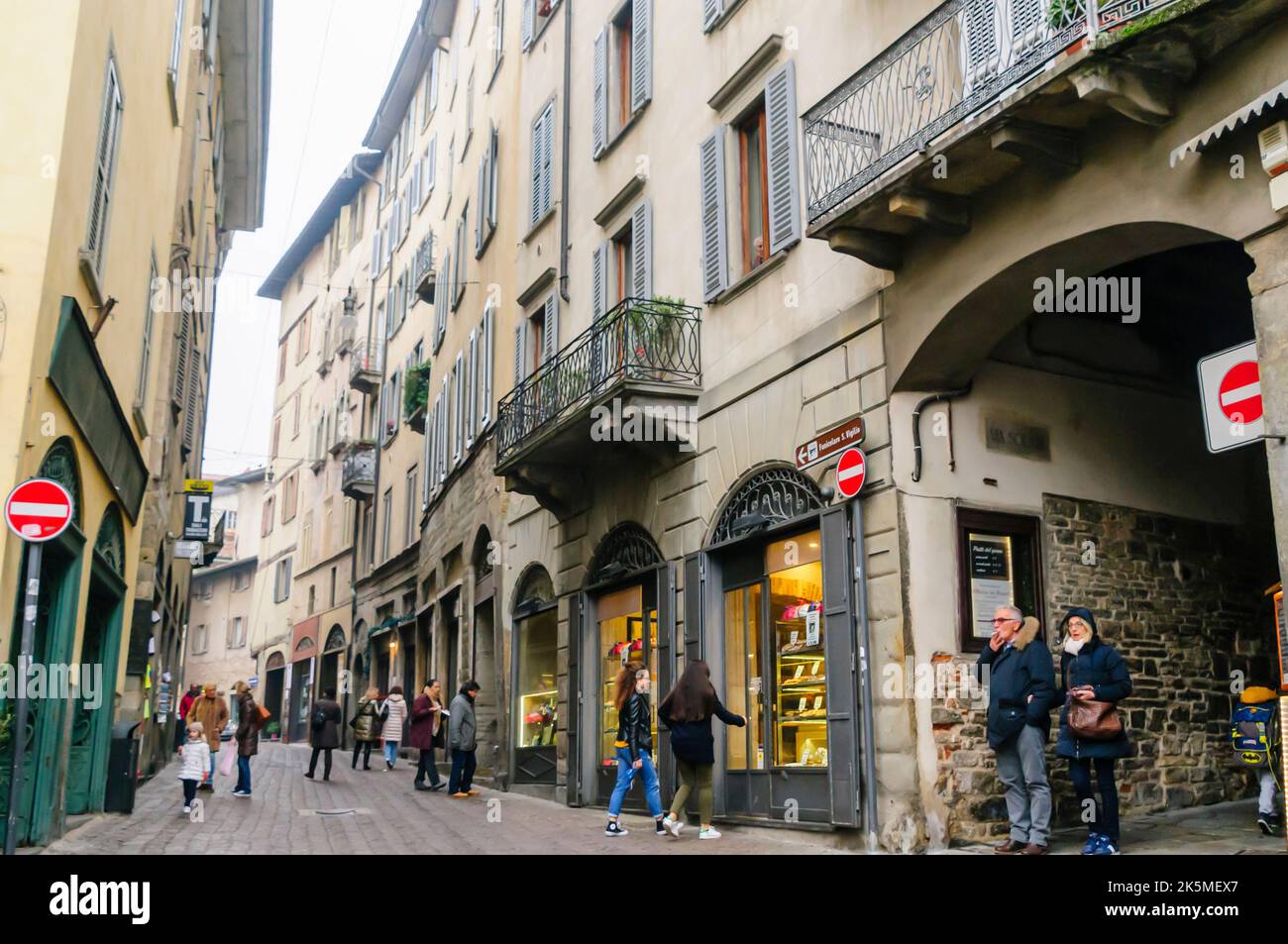Shoppers walk along the cobbled streets of Citta Alta, Bergamo, Italy ...