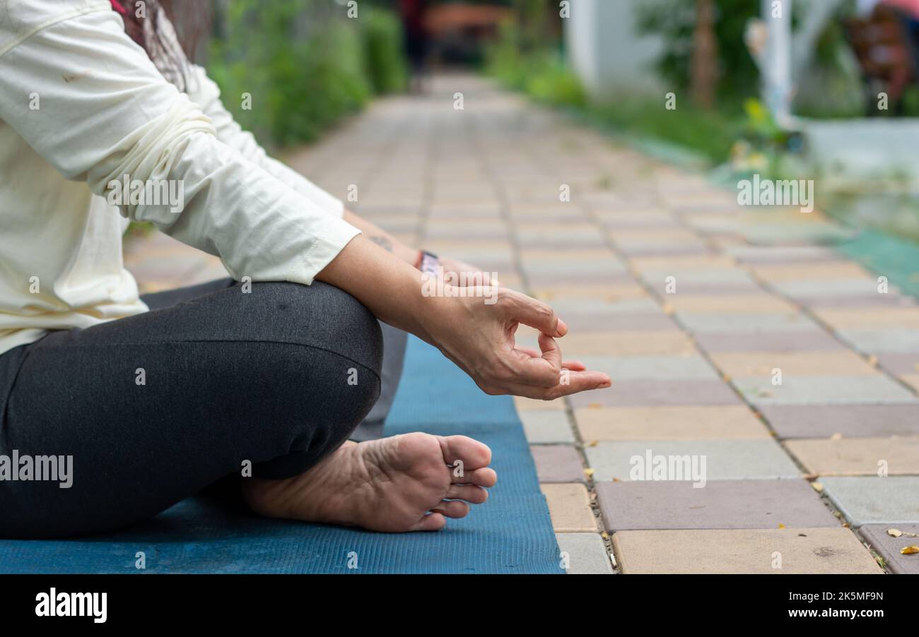 Close up woman mudra hand gesture doing yoga relaxing in lotus position ...