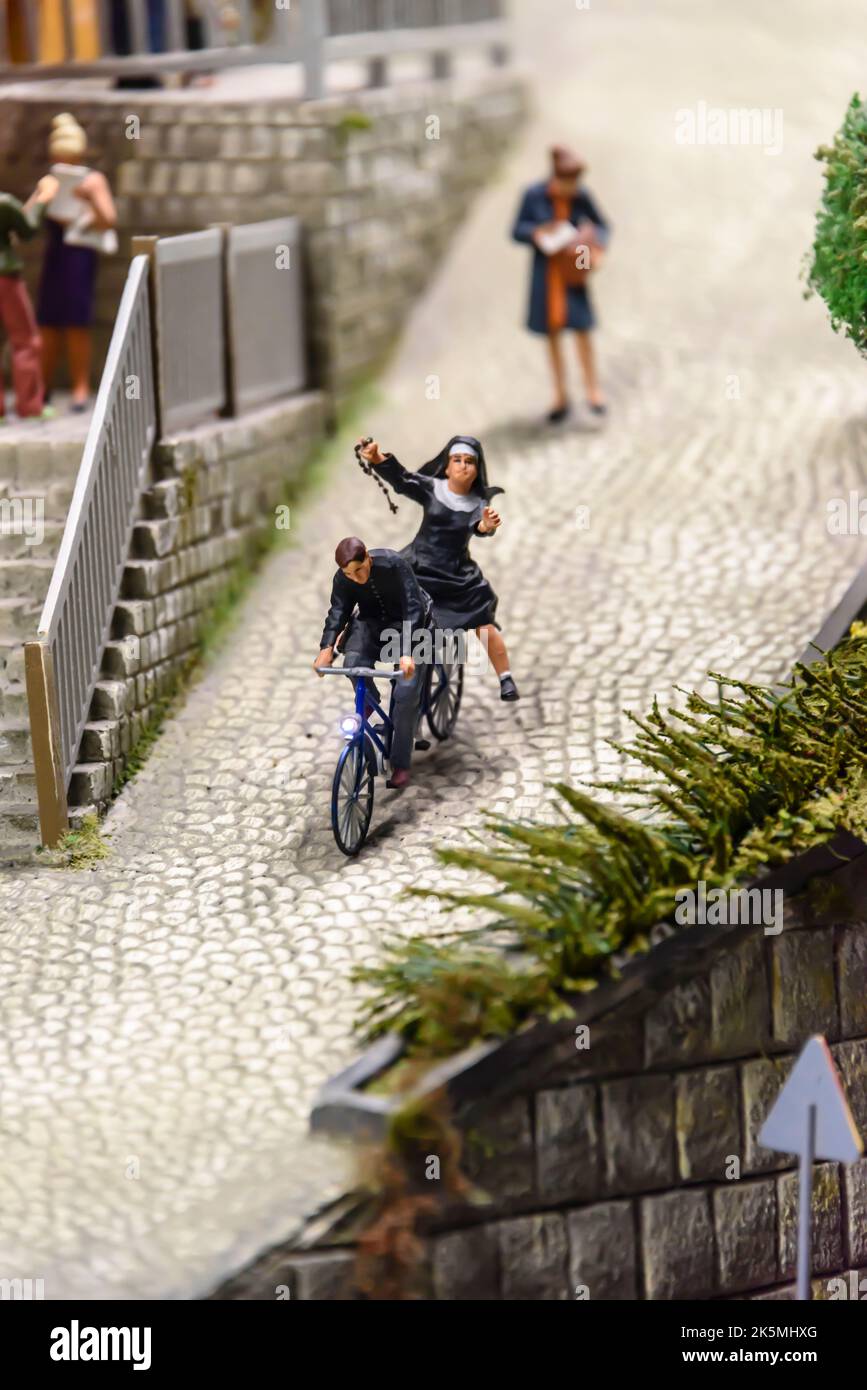 Miniature model of a priest and a nun on a bike going fast down hill ...