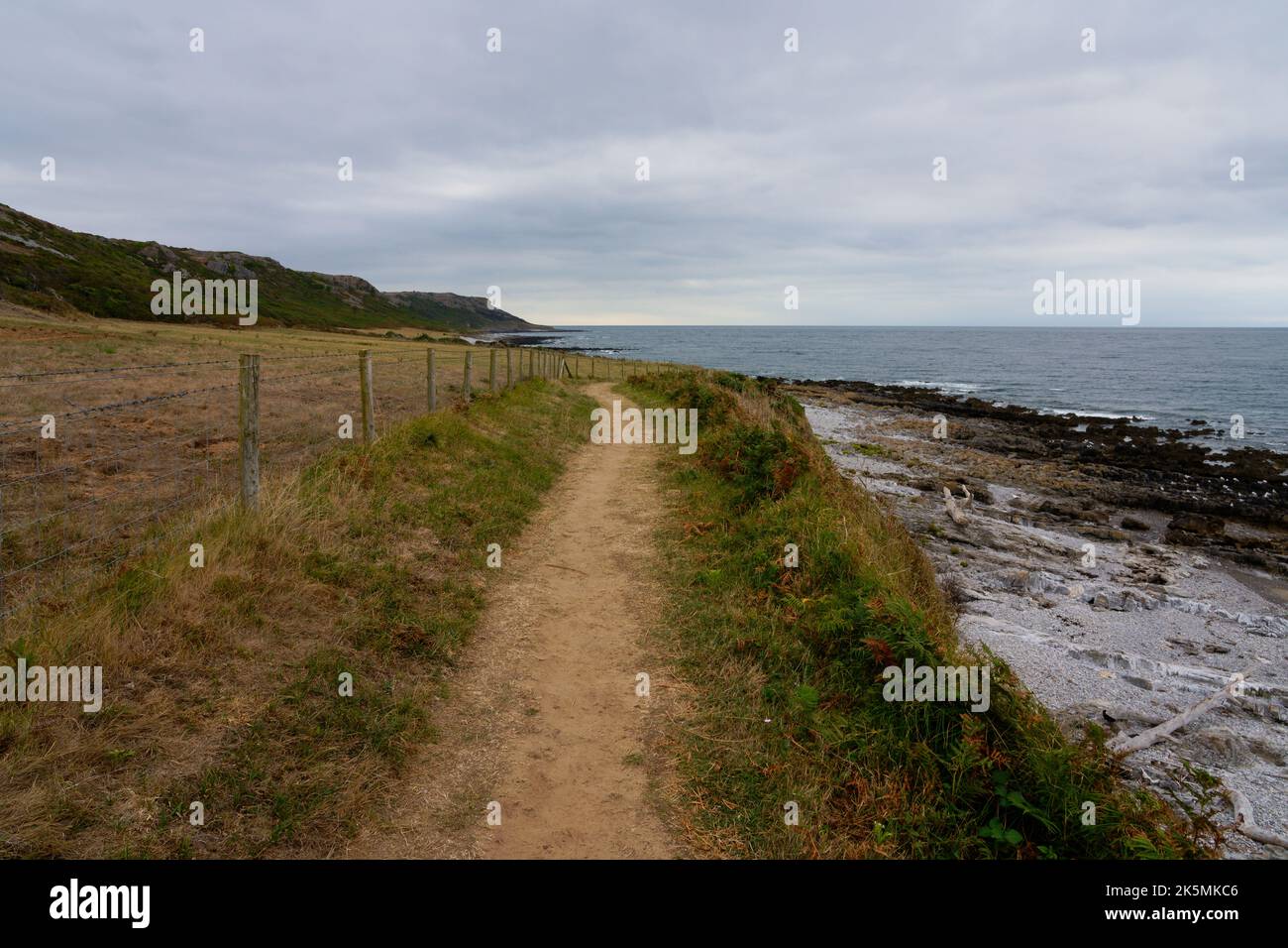 Sandy winding footpath above the rocky shores of the Gower Peninsula ...