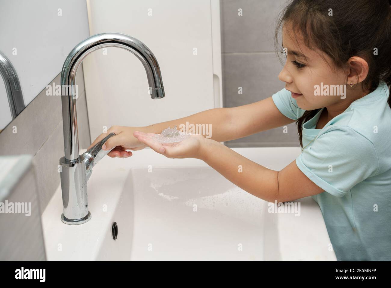 Children wash grown crystal. Chemical experiment on growing crystals in ...