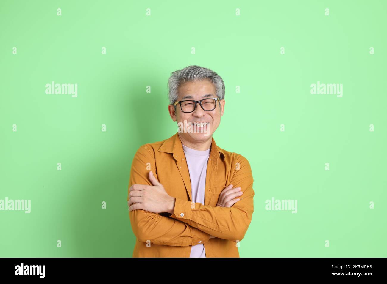 The 40s adult Asian man with yellow shirt standing on the green ...