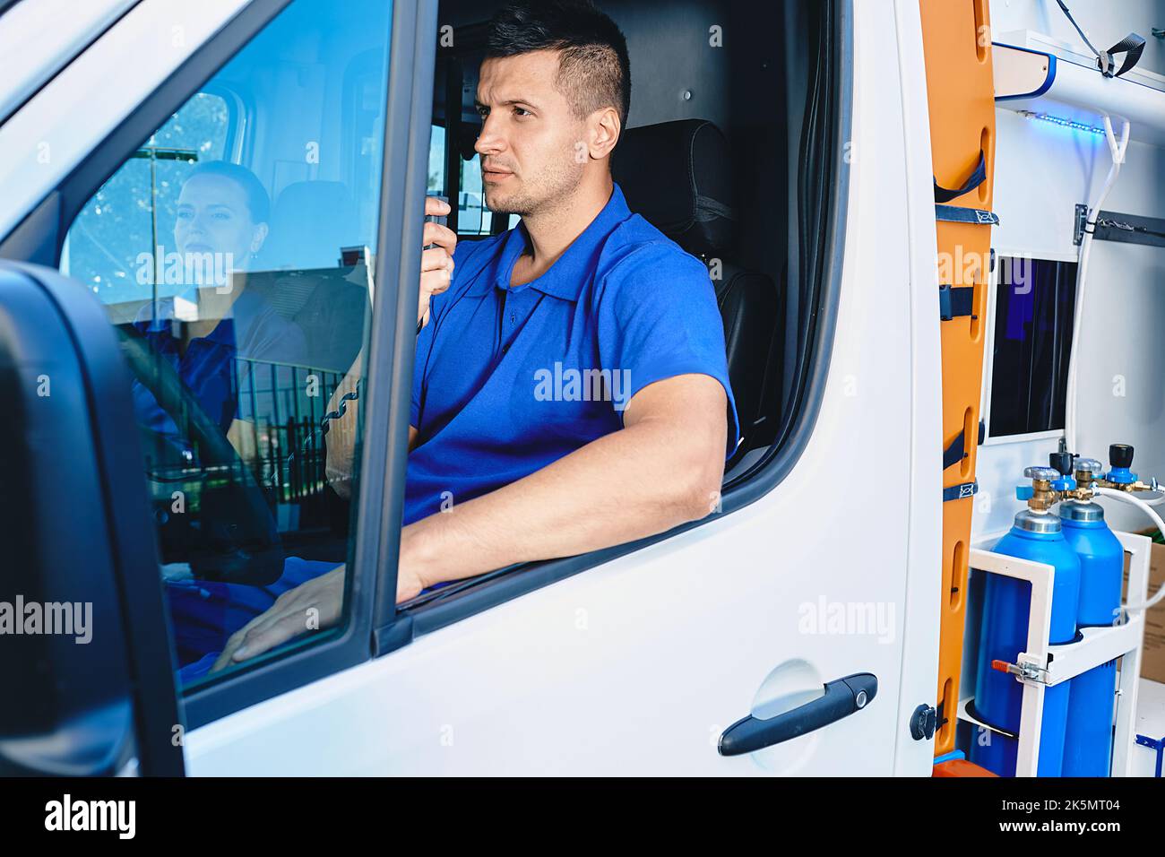 Team of paramedics preparing to leave for emergency ambulance call ...