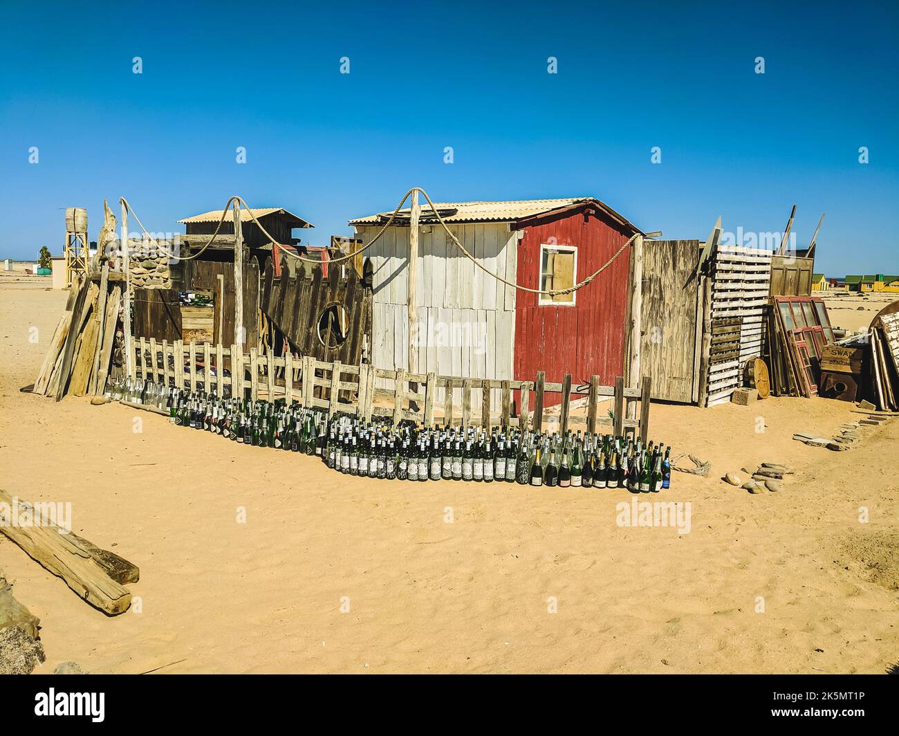Large number of empty wine and beer bottles outside a ramshackled house ...