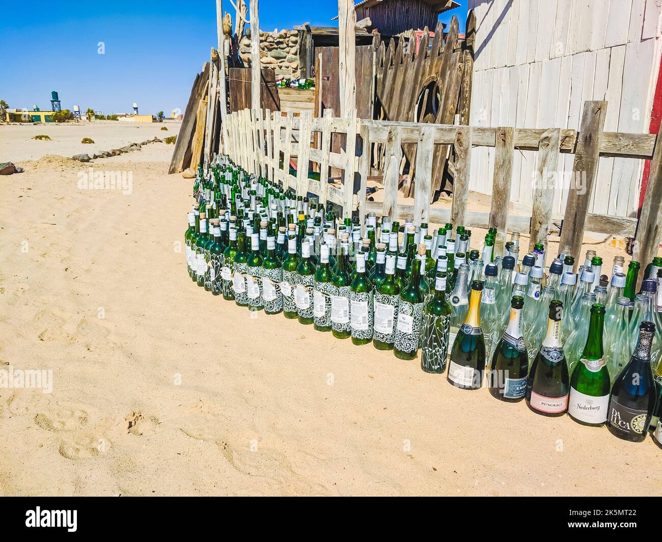 Large number of empty wine and beer bottles outside a ramshackled house ...