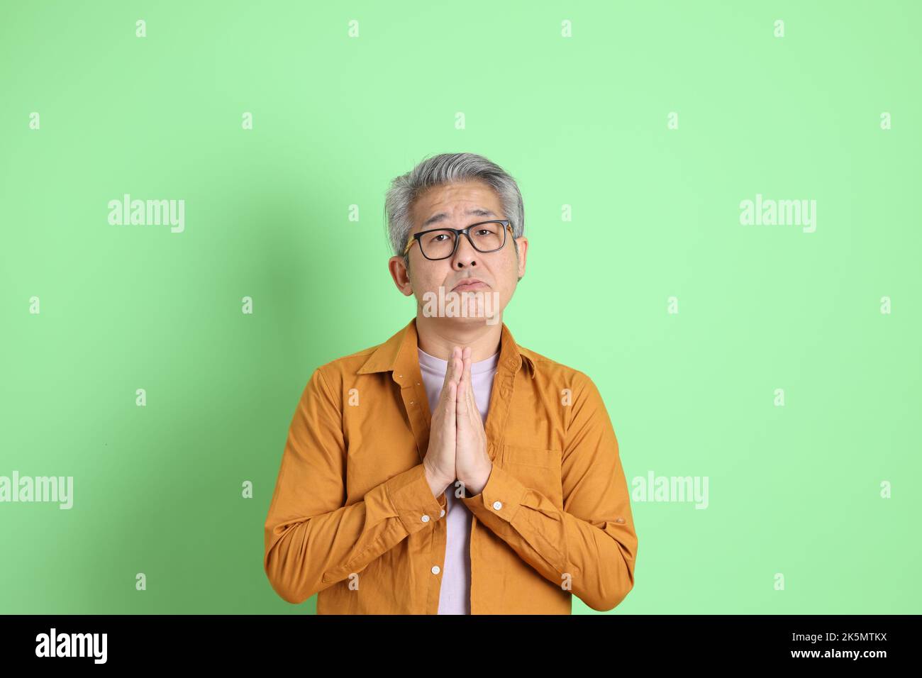 The 40s adult Asian man with yellow shirt standing on the green ...