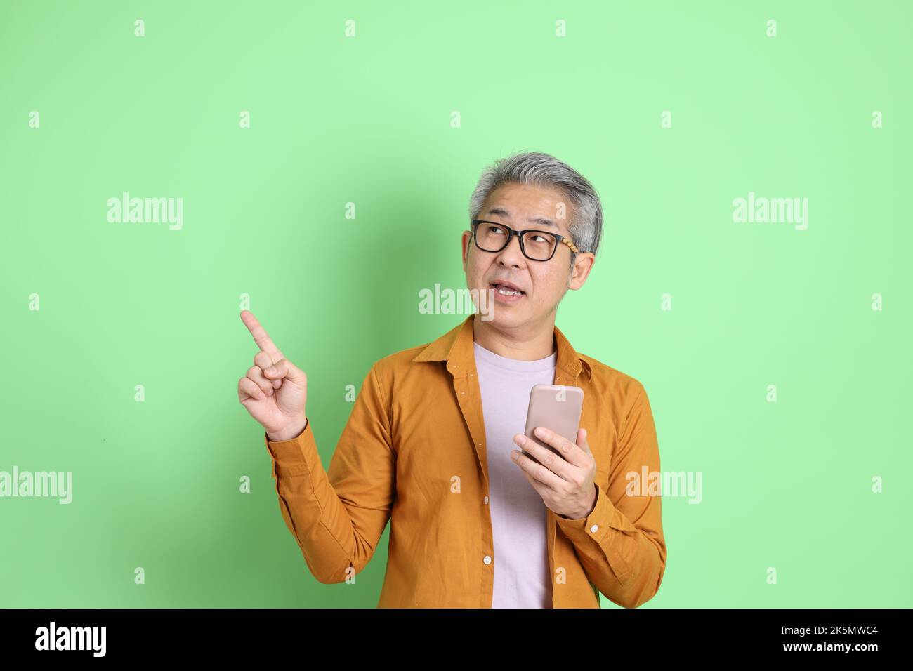 The 40s adult Asian man with yellow shirt standing on the green ...