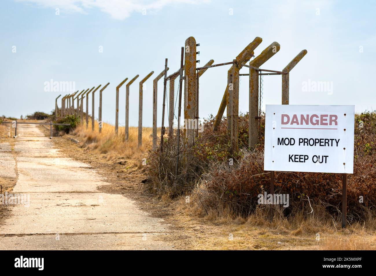 Roadway with remnants of concrete fencing poles with M.O.D. property ...