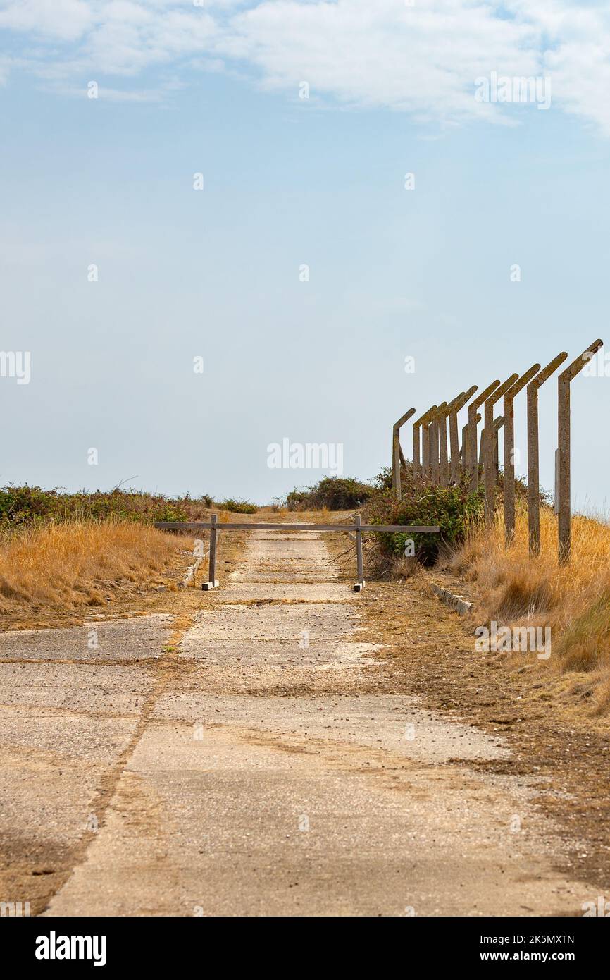Roadway with remnants of concrete fencing poles and gate, Orford Ness ...