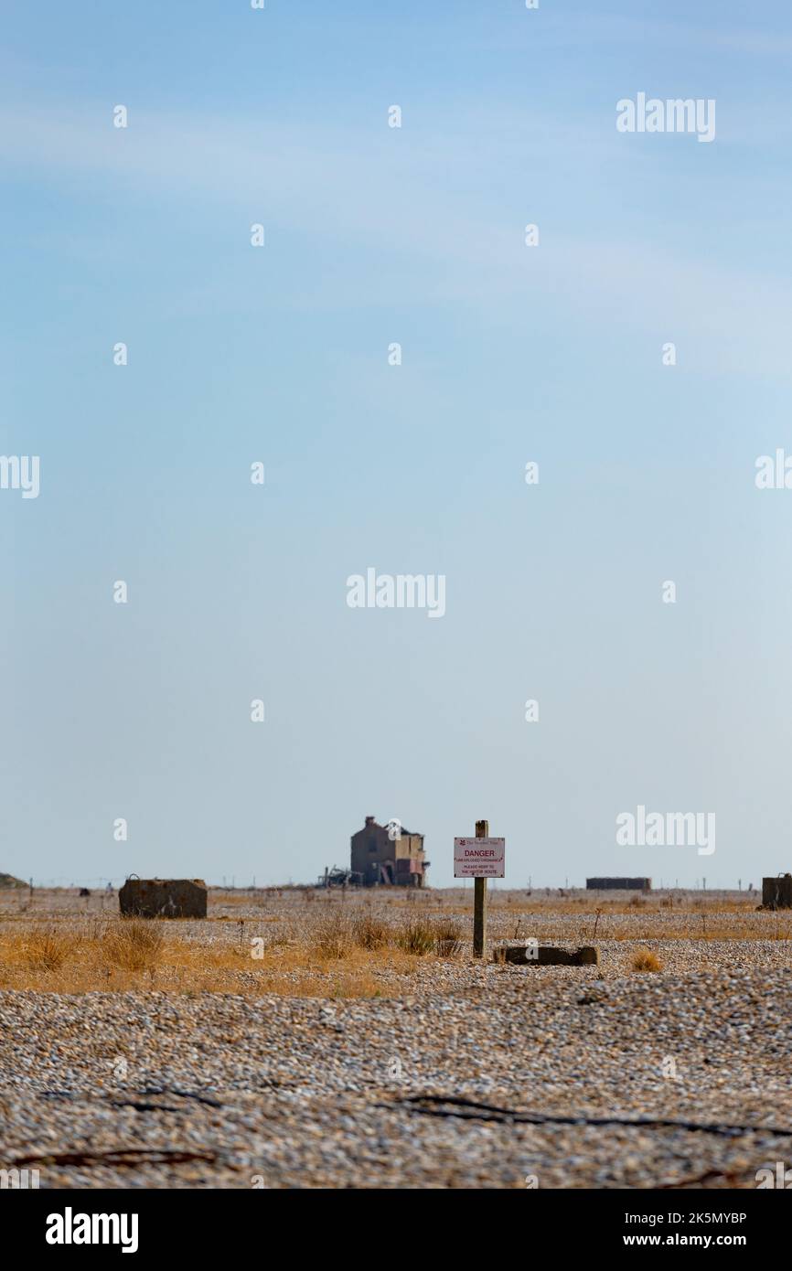 Flat shingle landscape with danger warning sign and buildings in the ...