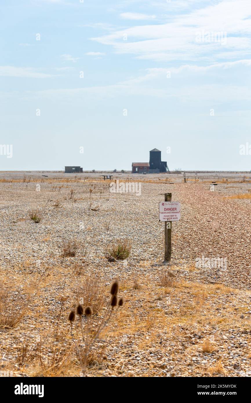 Flat shingle landscape with danger warning sign and buildings in the ...