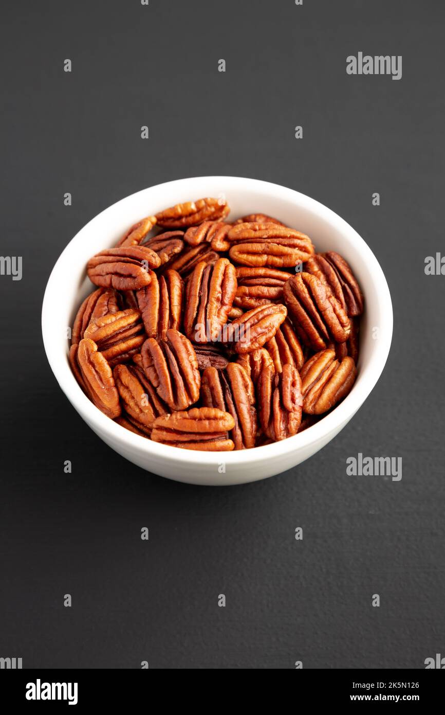 Homemade Shelled Pecans in a bowl on a black background, side view ...