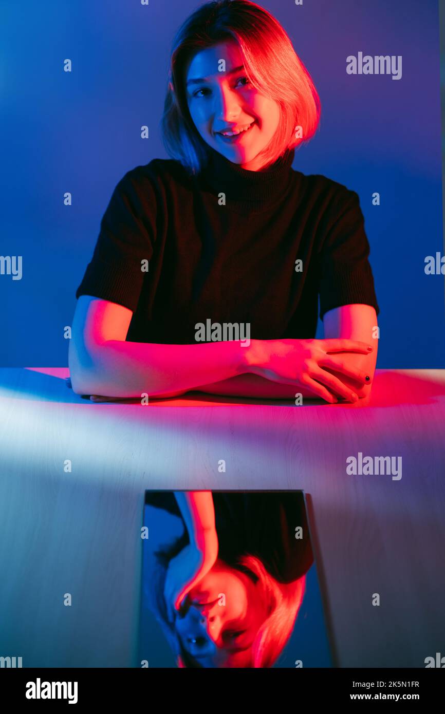 Double face. Neon light portrait. Pretending nice. Curious smiling girl ...