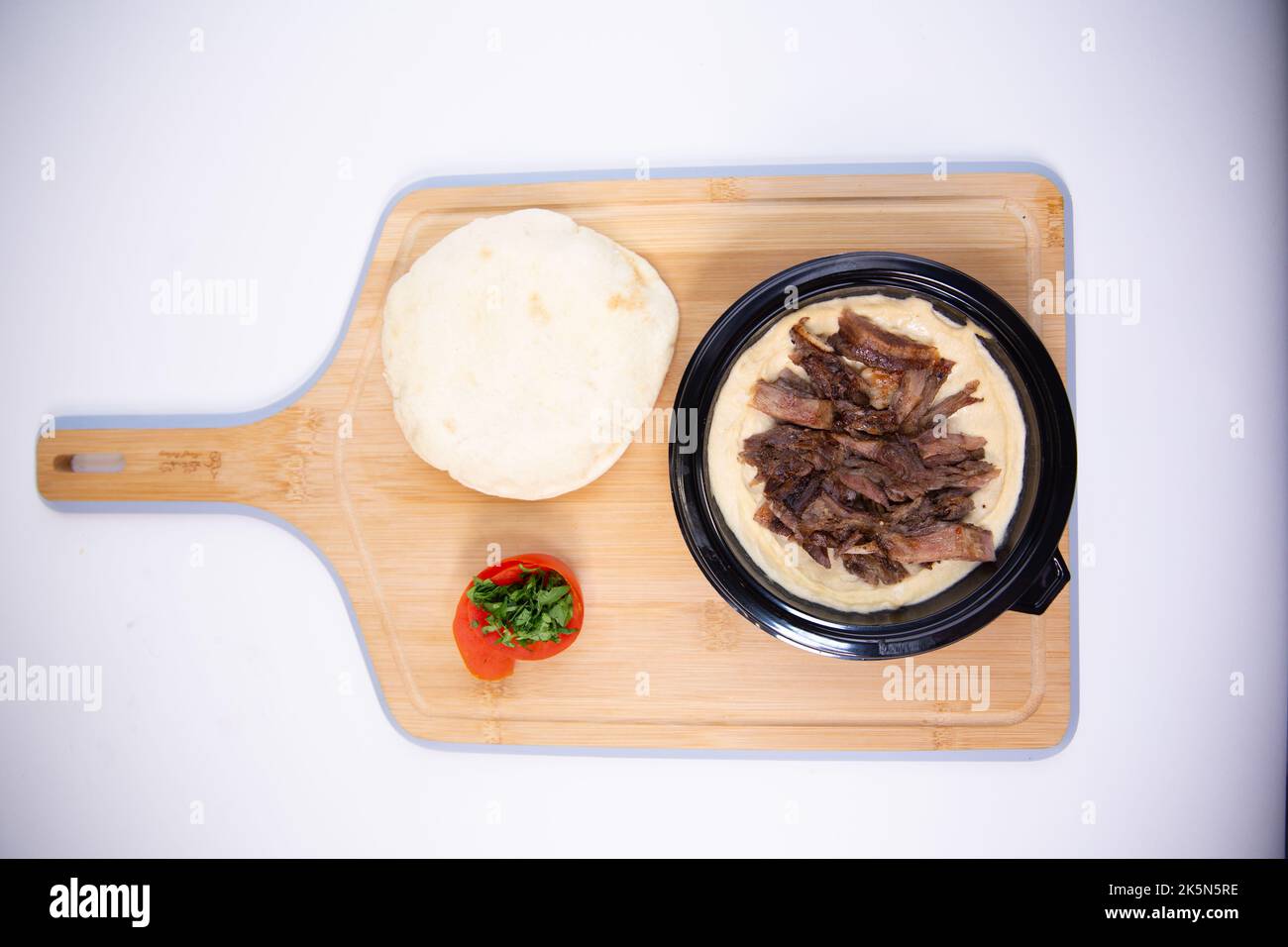 A top view of a Cassava roti Kibbeh nayyeh and a stuffed tomato on a ...