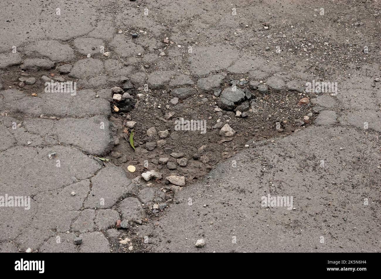 A hole in the asphalt with pieces of broken asphalt Stock Photo - Alamy