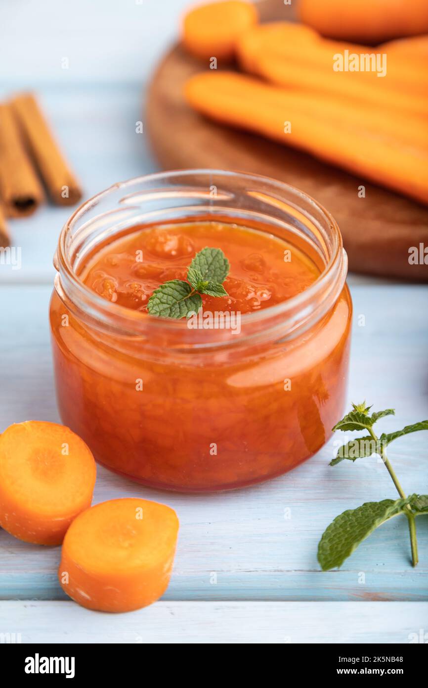Carrot jam with cinnamon in glass jar on blue wooden background. Side ...