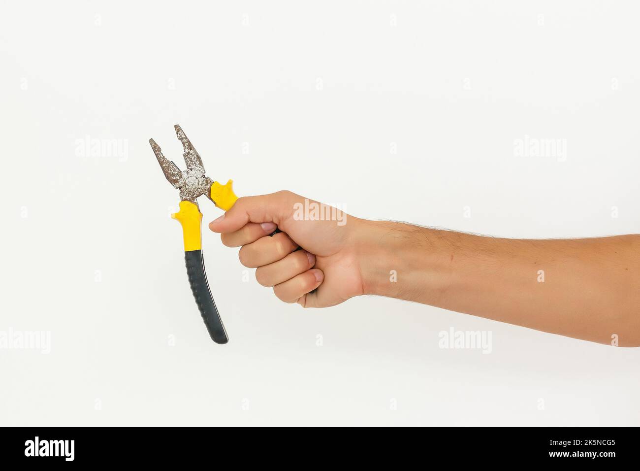 The hand of the mechanic is holding a plier isolated on white ...