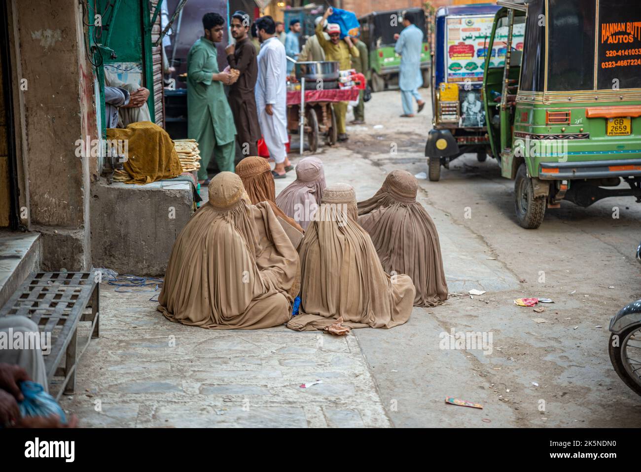 Women with burqa sitting on the sidewalk,Peshawar, Khyber Pakhtunkhwa ...