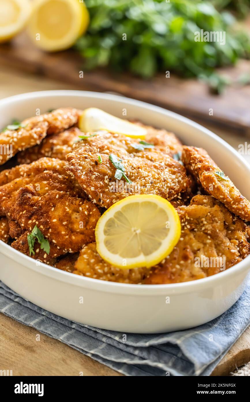 Detail of crispy fresh schnitzels with sesame seeds served with slice ...