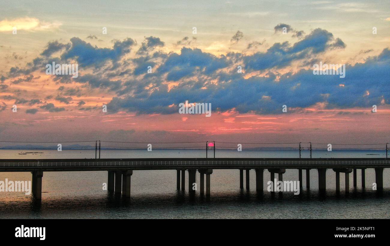 A scenic view of Shishu lake and bridge at sunset with the yellow ...