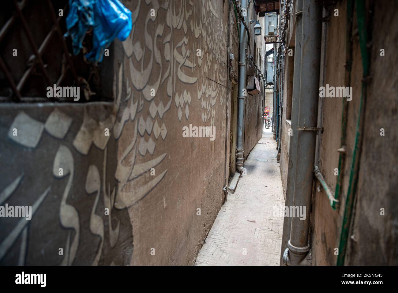 A very narrow alley in downtown with arabic inscriptions, Lahore ...
