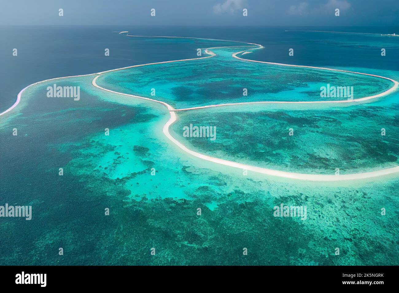 An aerial view of an atoll with an underwater coral reef seen through ...