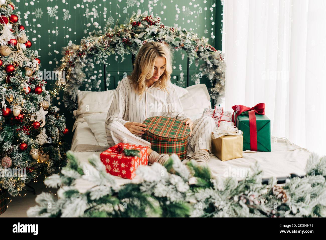 A woman in pajamas opens Christmas gifts Stock Photo - Alamy
