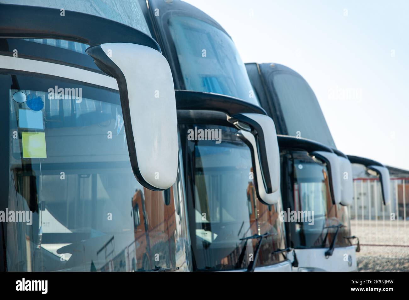 A detail of a row of luxury buses parked on the construction site for ...