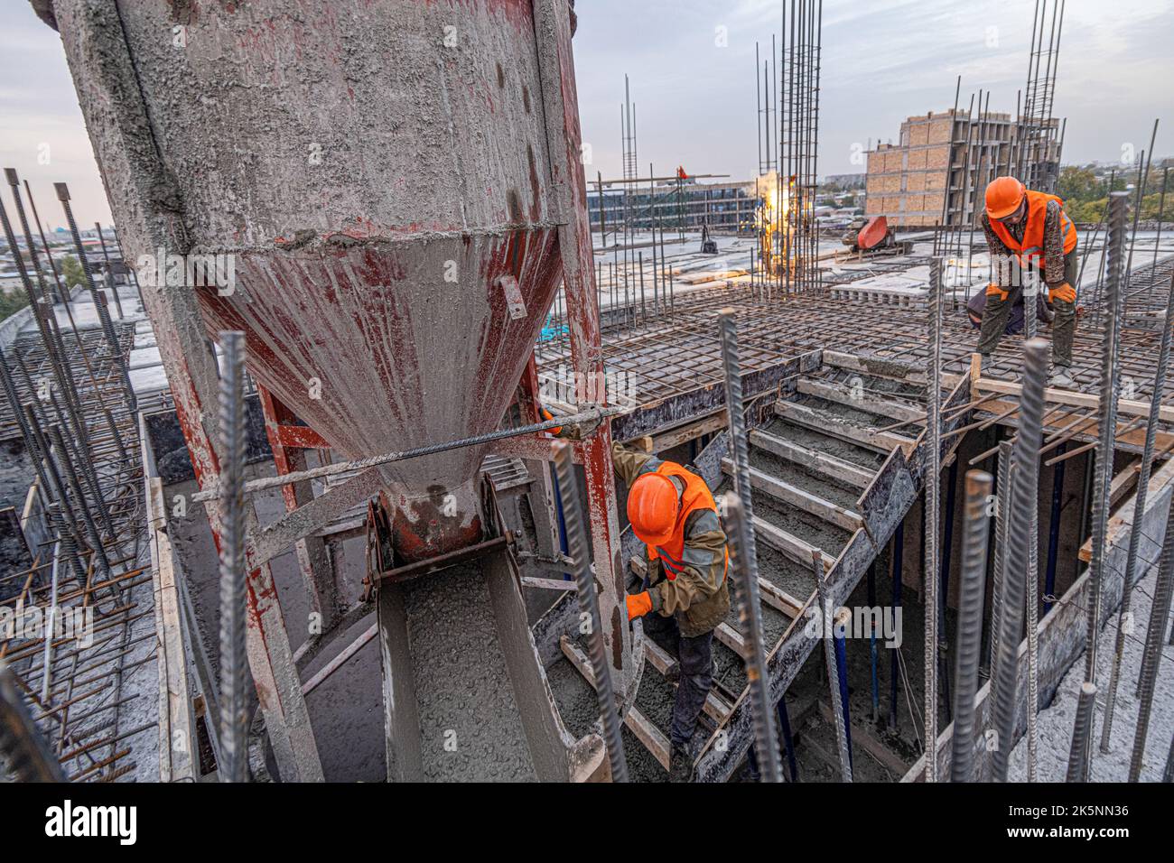 A high-angle shot of men working on the concrete pouring bucket in the ...