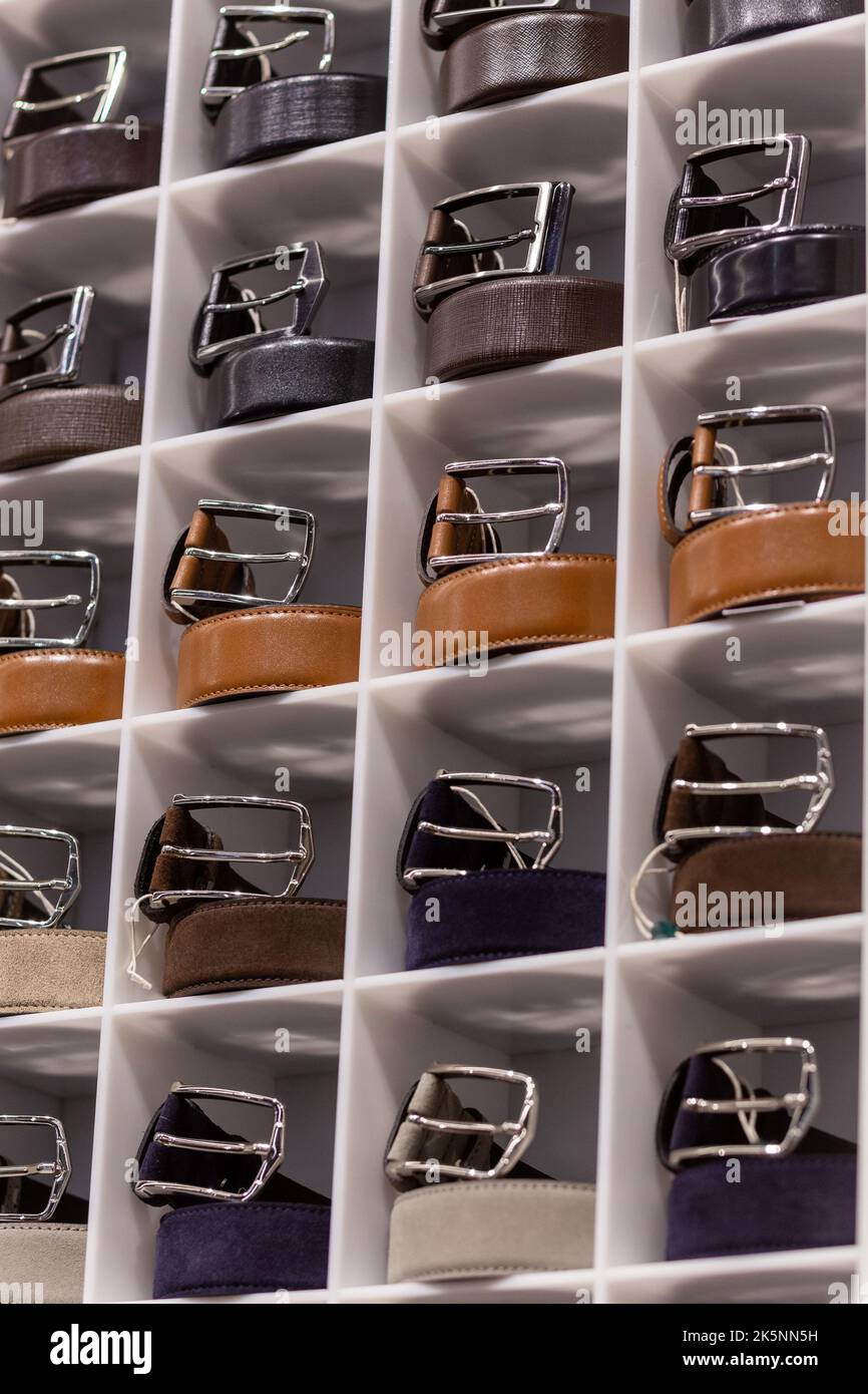 Various coloured leather belt display on shelf in the store in a men ...