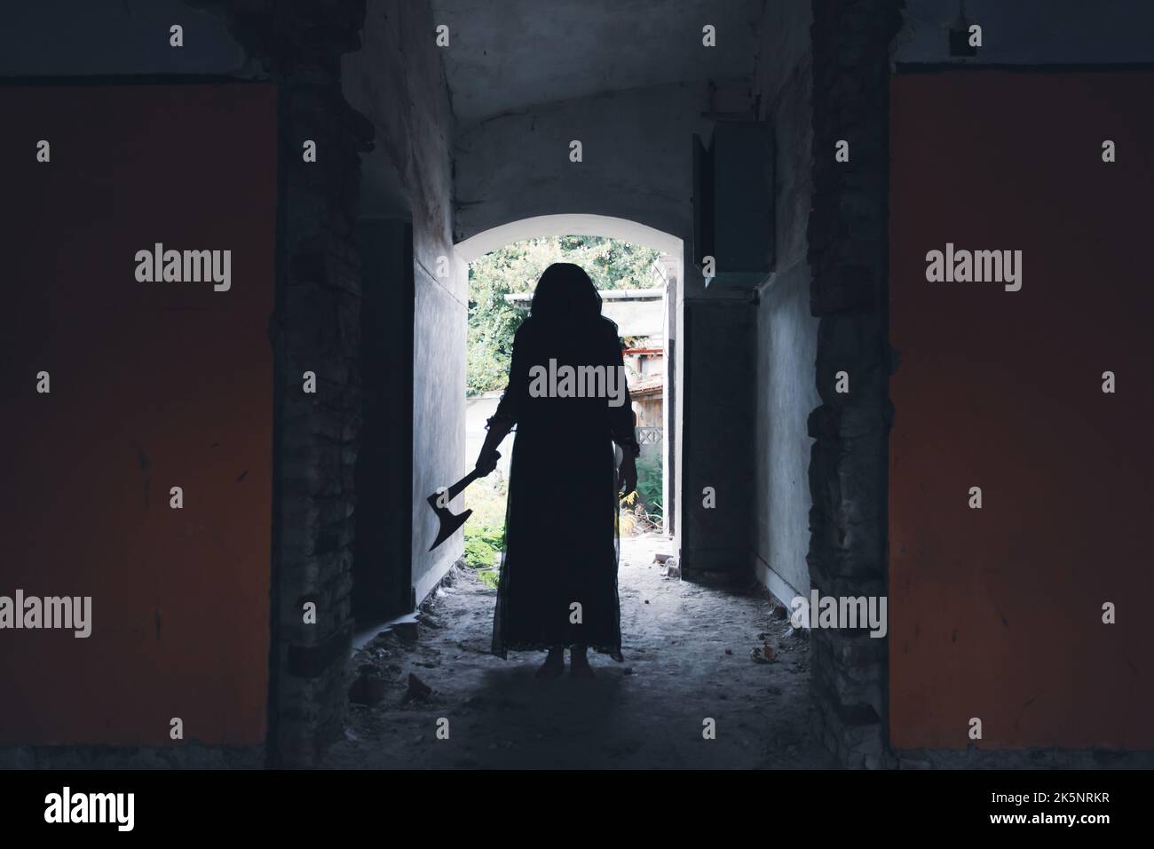 Ghost in abandoned, haunted house. Horror scene of spooky silhouette holding old axe, halloween ...