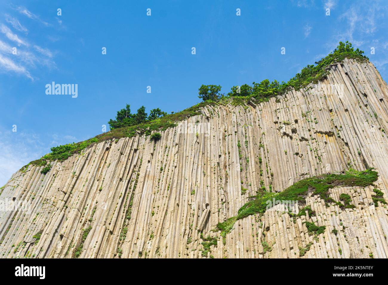 top of columnar volcanic basalt cliff against the background of the sky ...
