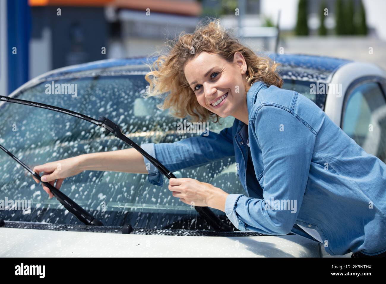 beautiful woman picking up windscreen wiper and checking it Stock Photo ...