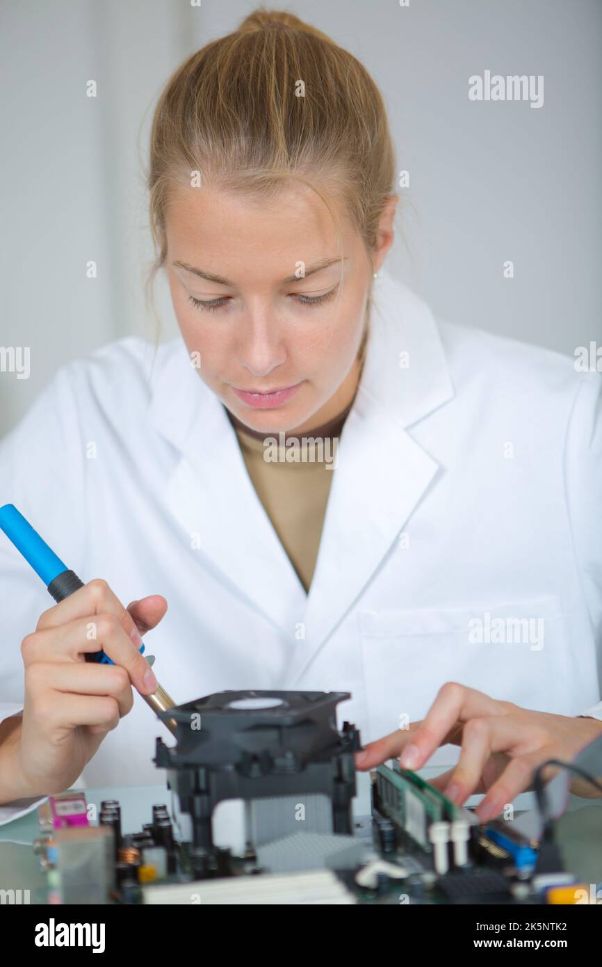 female electronic engineer testing computer motherboard in laboratory ...