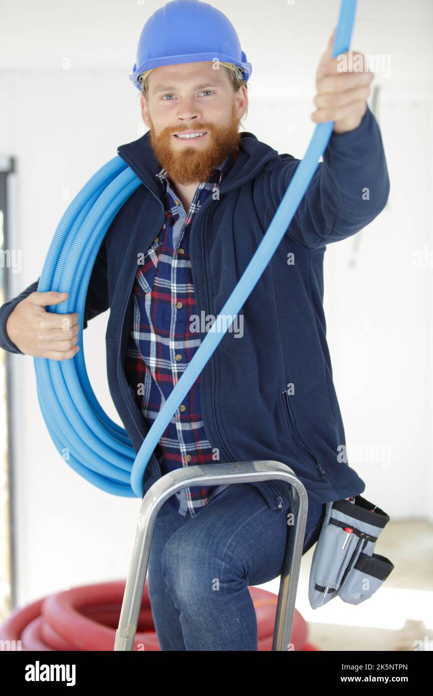 worker at a construction site with pipes in his hand Stock Photo - Alamy