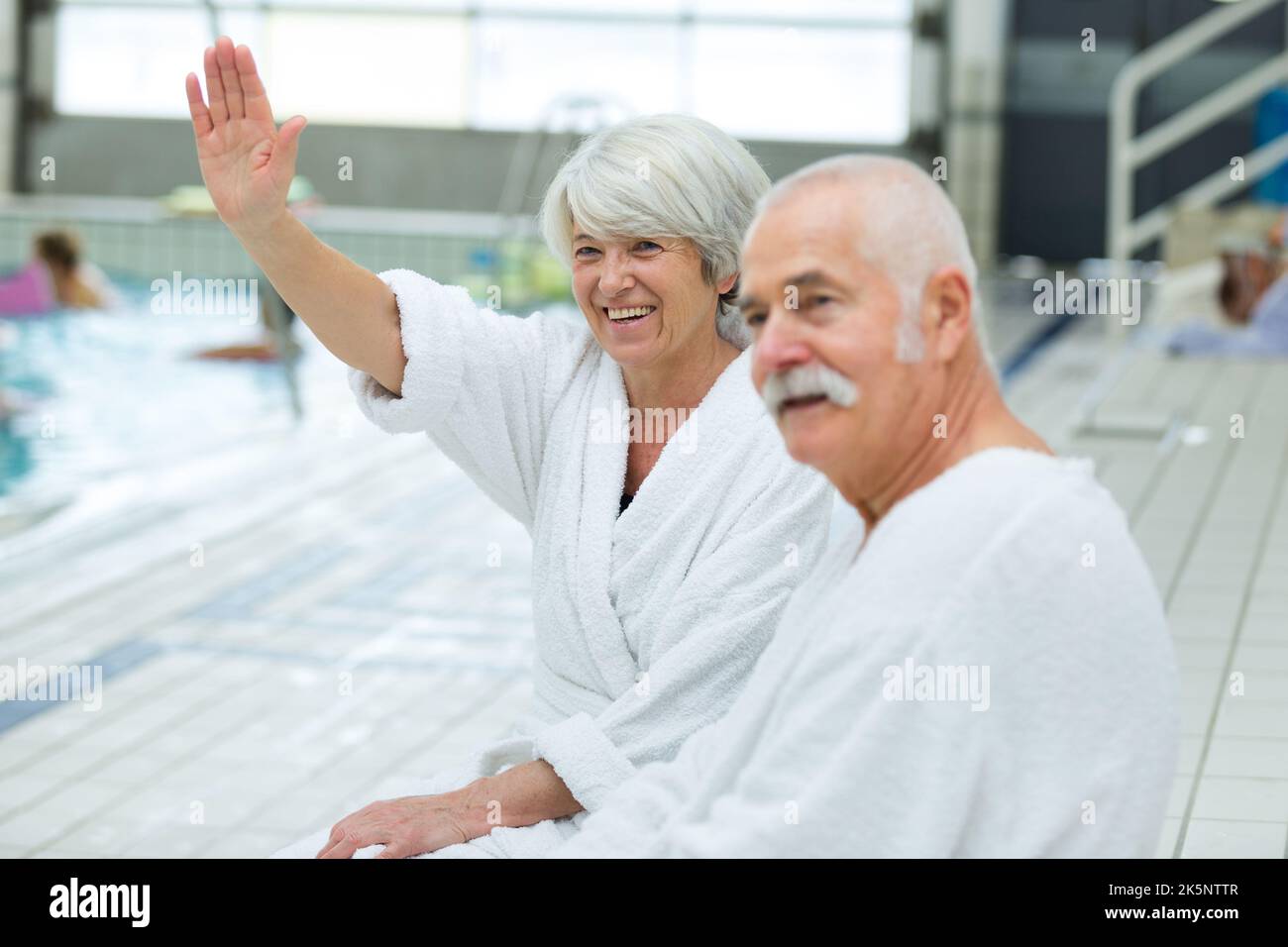 elderly couple waving in swimming pool Stock Photo - Alamy